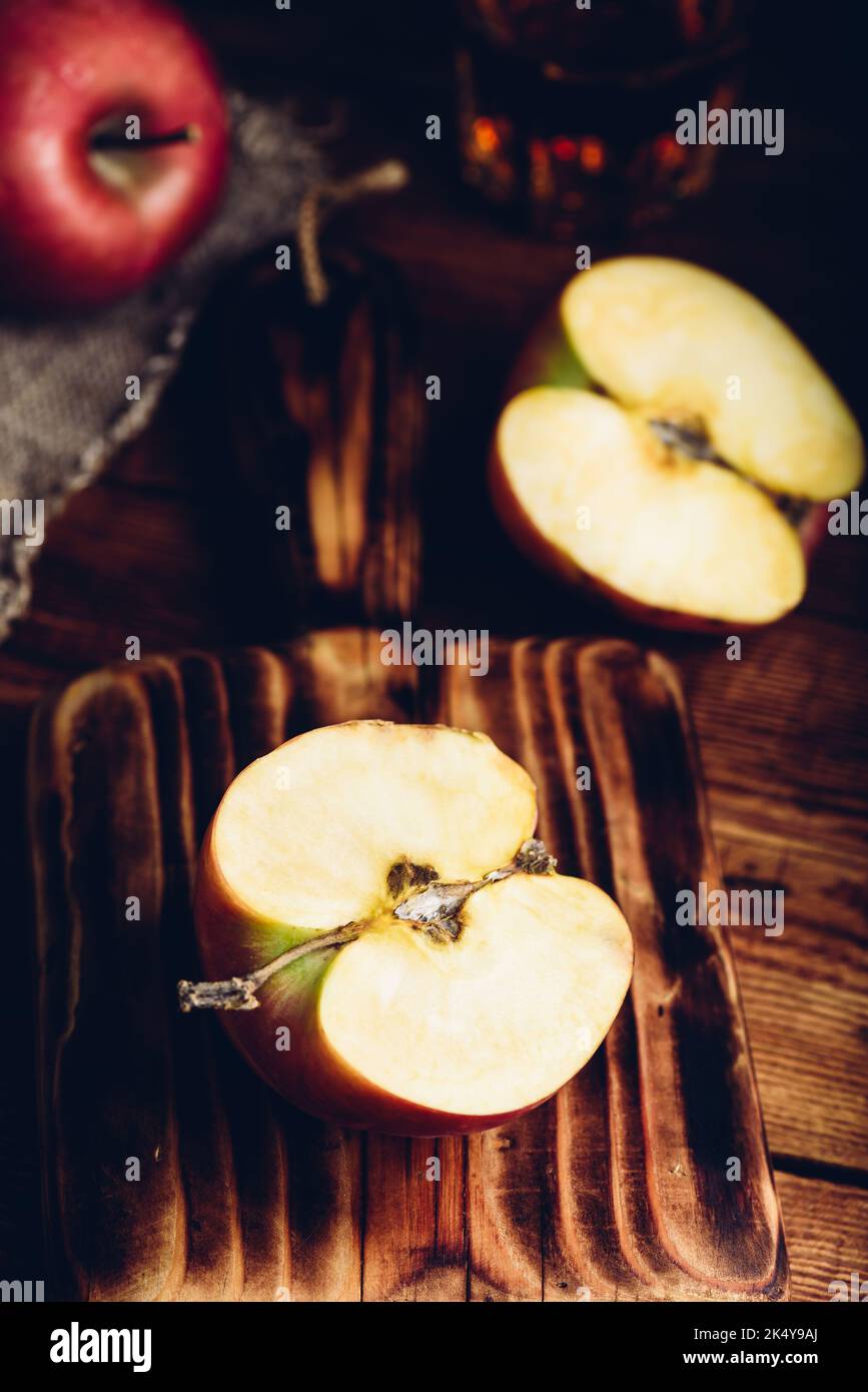 Halved Red Apple on Cutting Board in Rustic Setting Stock Photo - Alamy