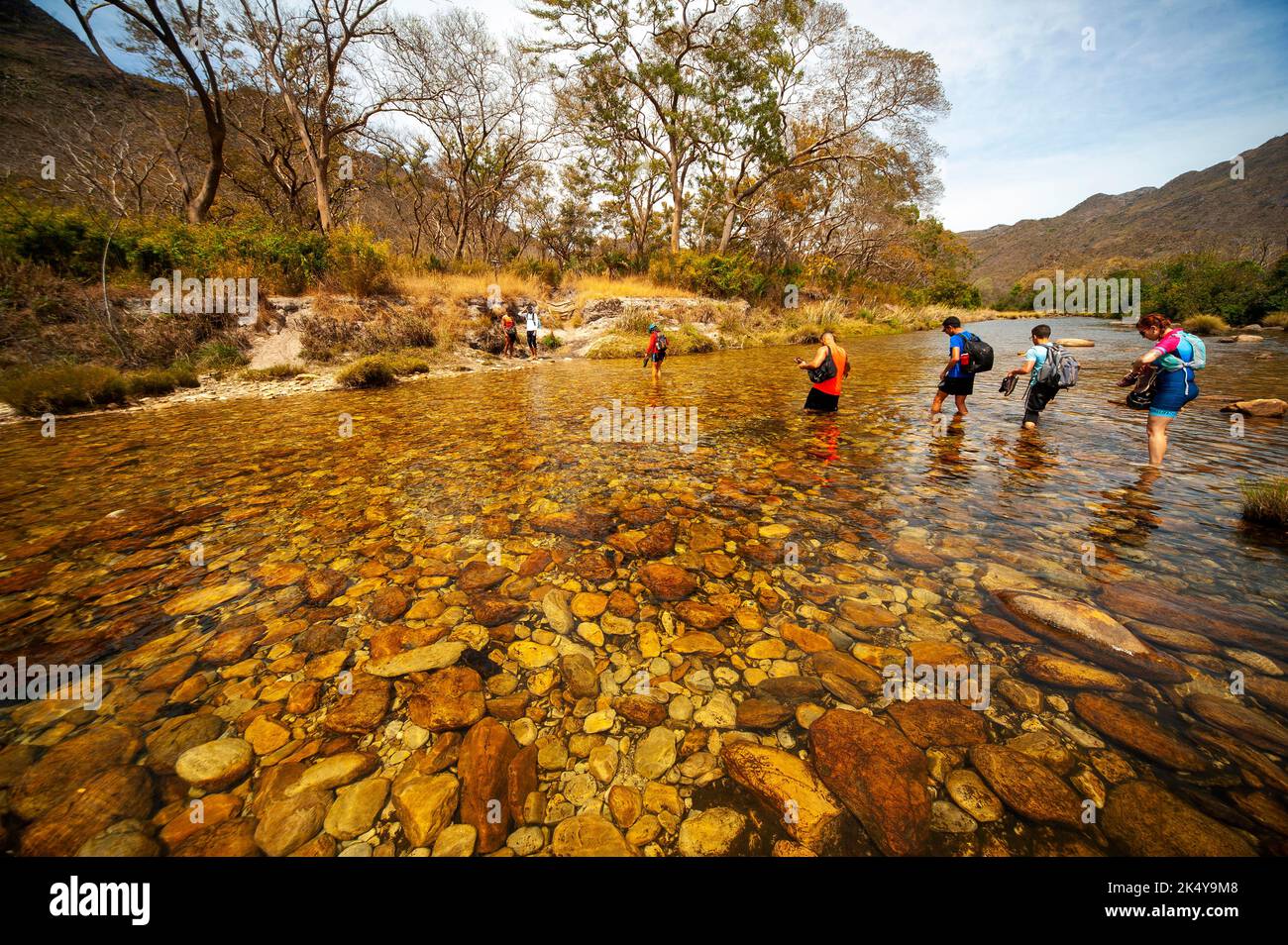 Tourists crossing the Mascates stream on the way to Bandeirinhas Canyon ...