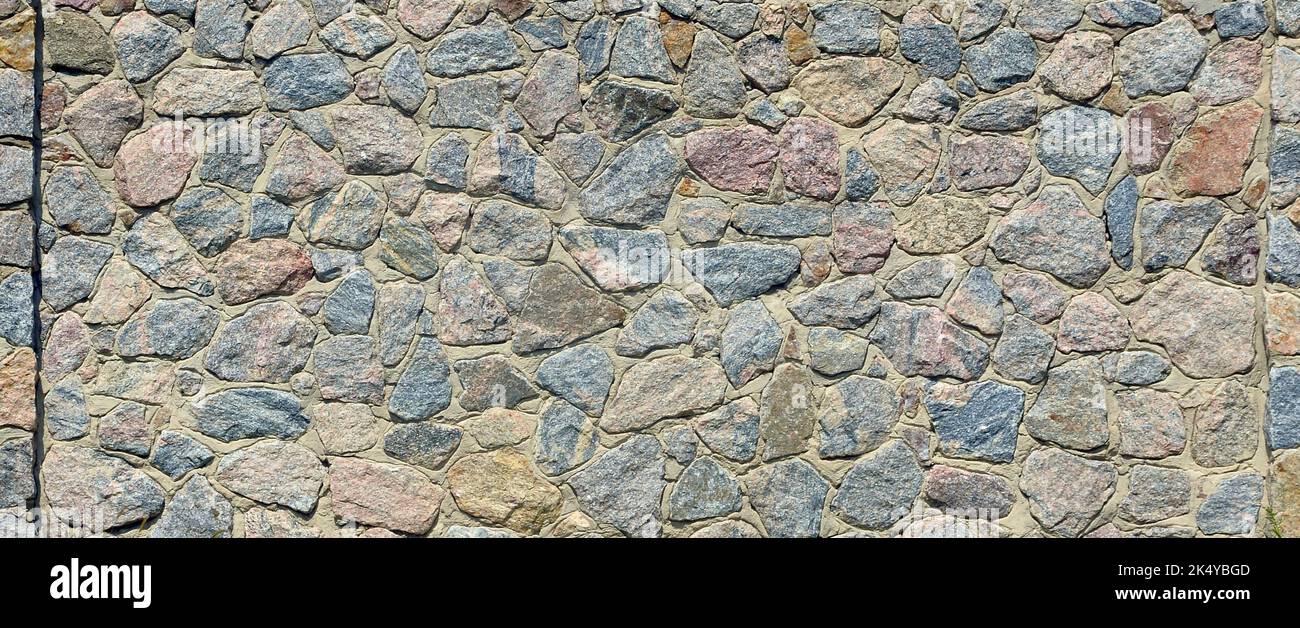 Texture of a stone wall with many big brown and grey stones armed with ...