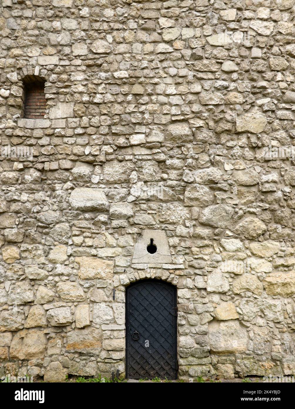 Texture of medieval stone wall and old metal door. Old castle stone wall texture background for ...
