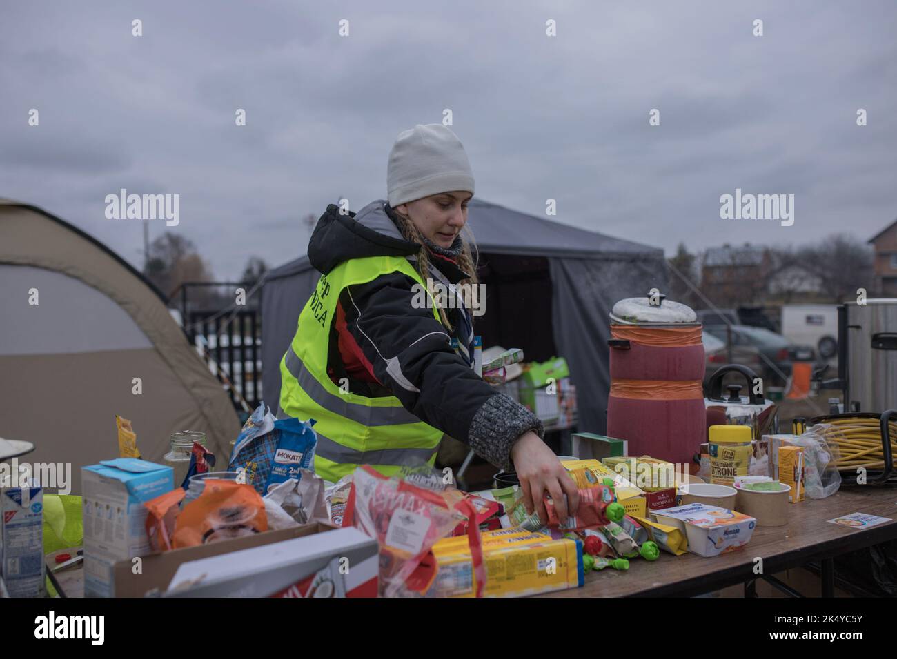 A volunteer woman serve food at the Medyka border crossing in Medyka ...