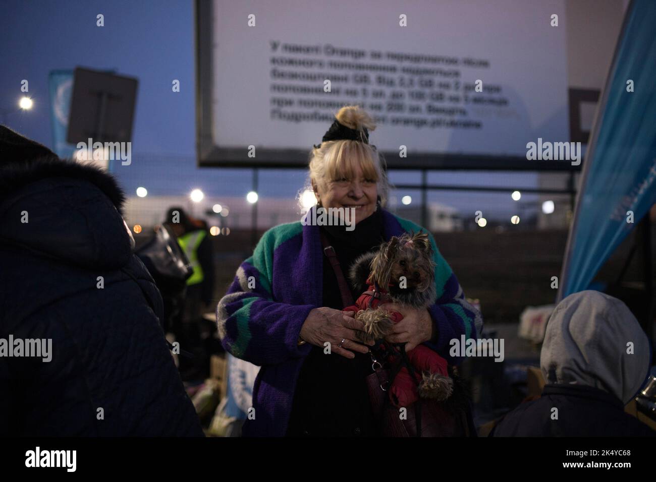 A displaced Ukrainian woman holds her dog at the Medyka border crossing ...