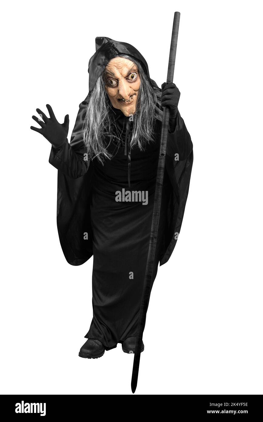 Old witch in a cloak standing with a stick isolated over white ...