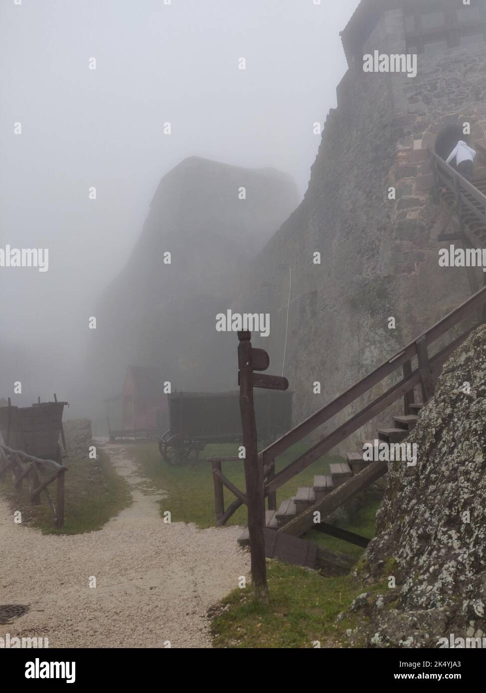 A vertical shot of 13th-century Visegrad Citadel exterior design in fog ...
