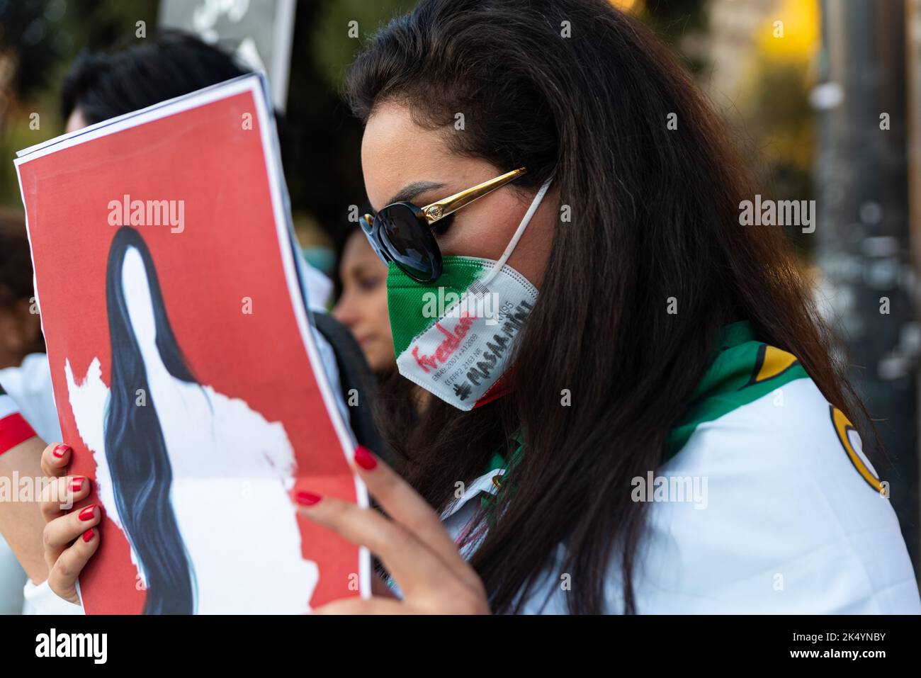 A woman wearing a face mask with the Iran flag is seen during the ...