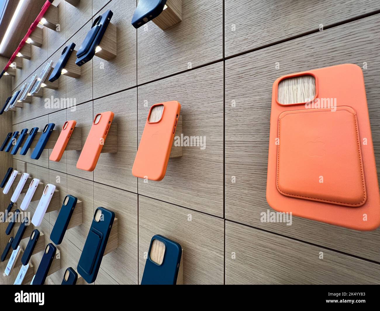 iPhone coloured casing on shelf display in-store for sales at Apple ...