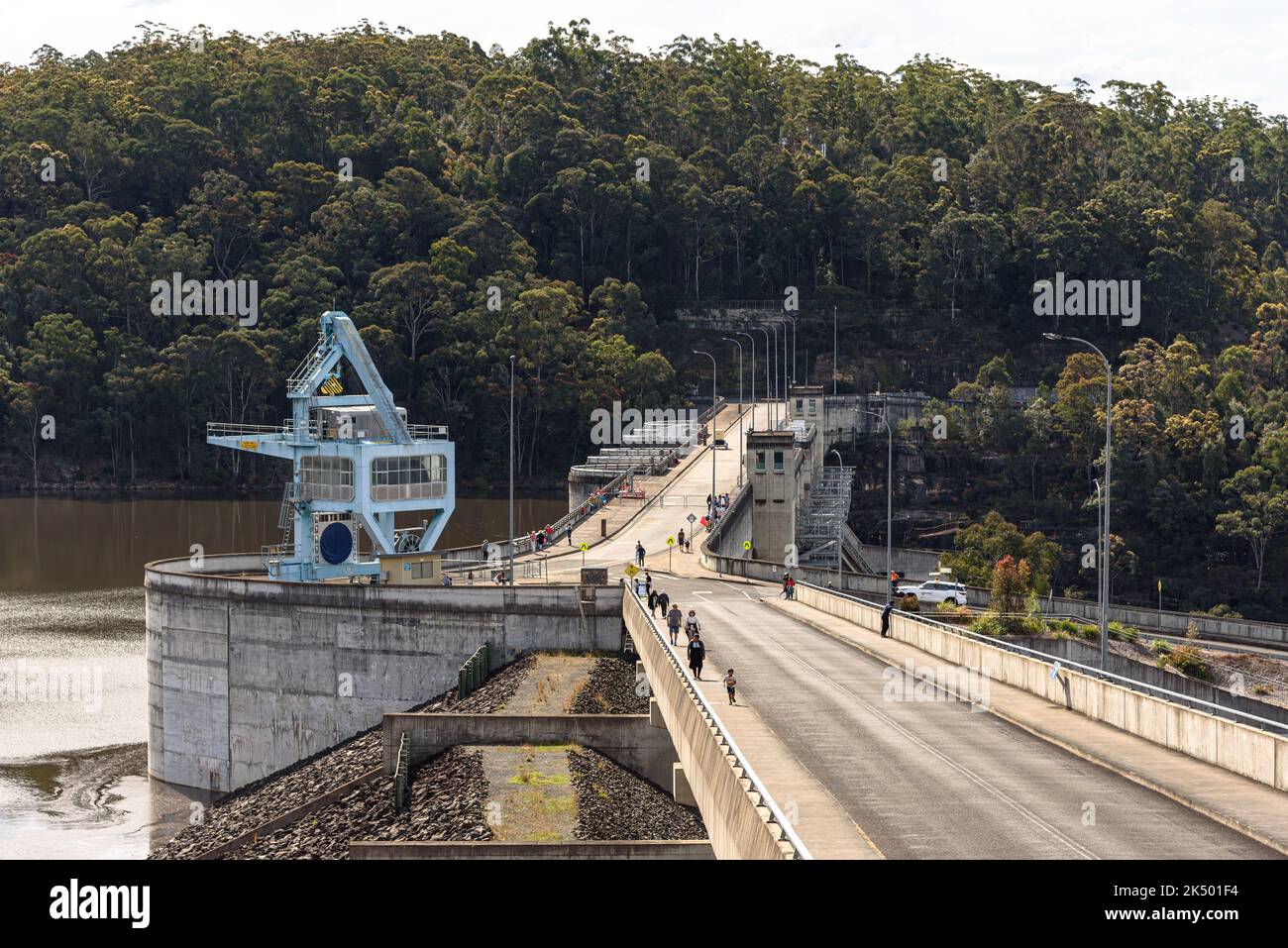 People walking on the road atop the wall of the Warragamba Dam, at full ...