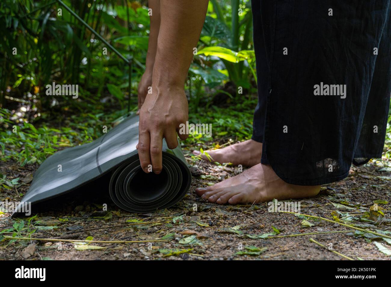 Young latin man arranging his yoga mat, inside a forest on a plain ...