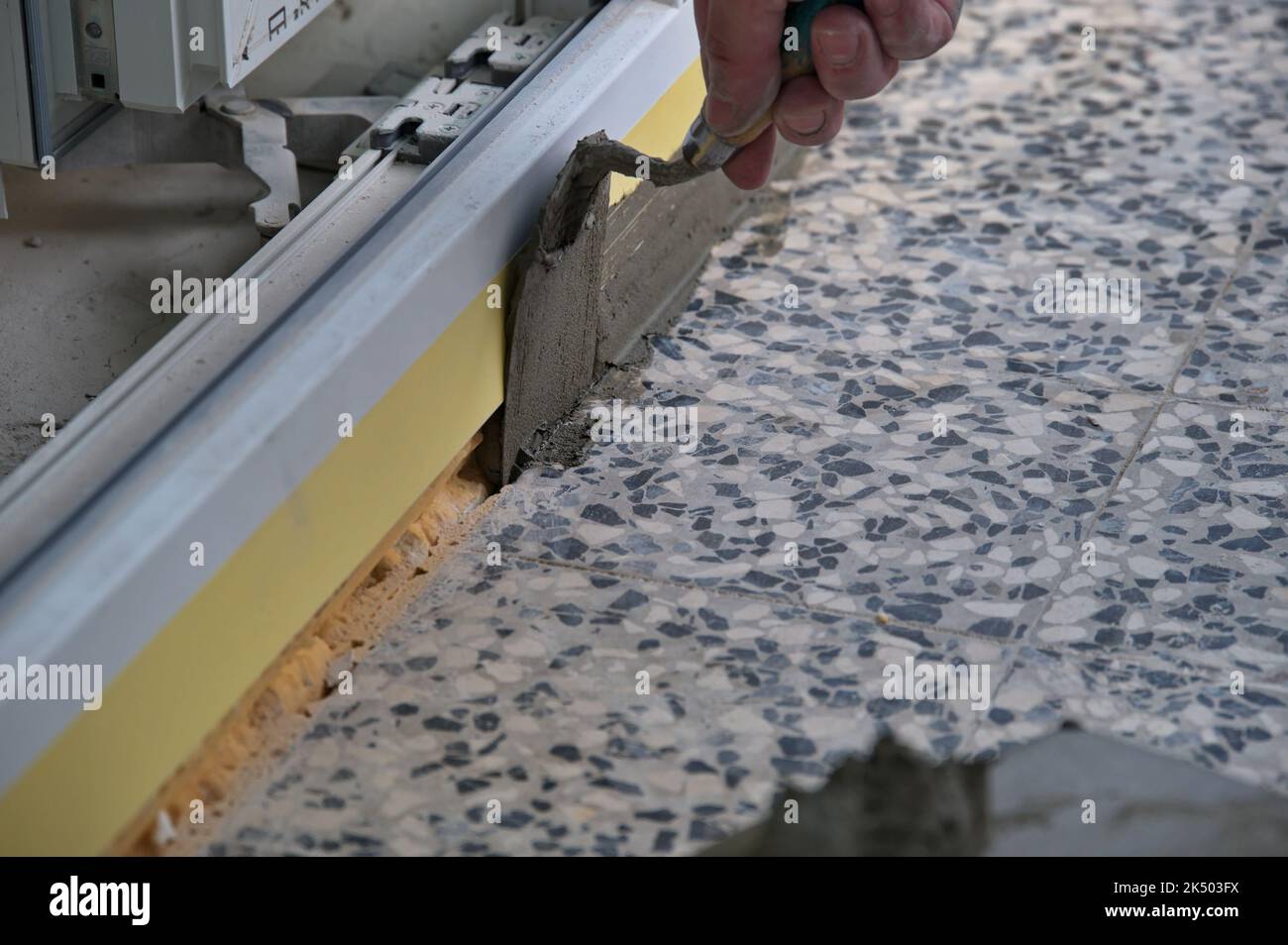 Hand builder with trowel leveling concrete Stock Photo - Alamy