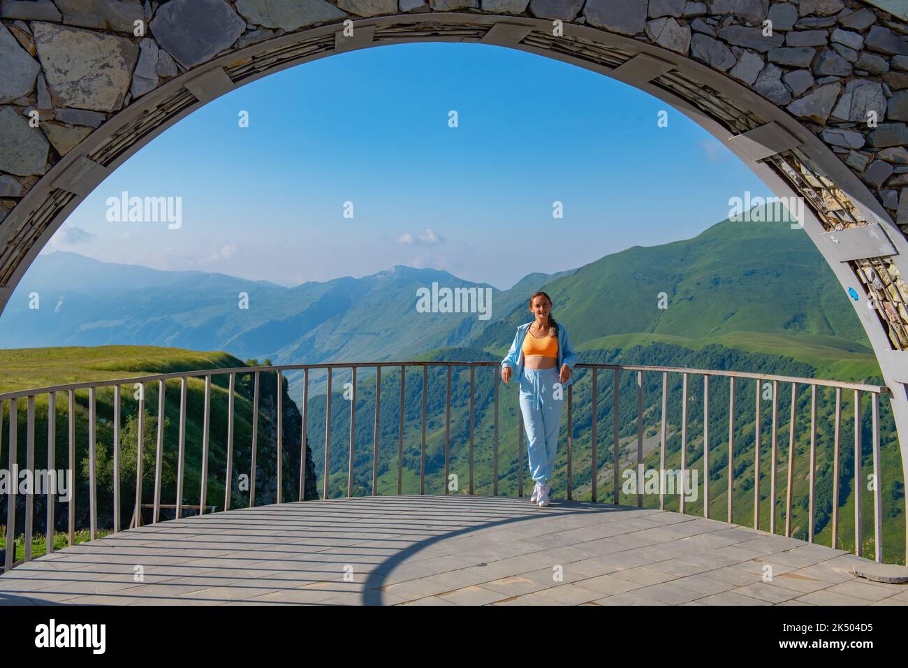 a girl stands on the Arch of Friendship on the Georgian Military ...