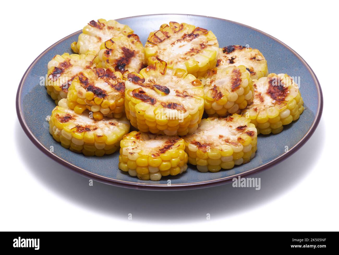 Grilled Slices of corn cobs with stripes from a grill in ceramic plate ...