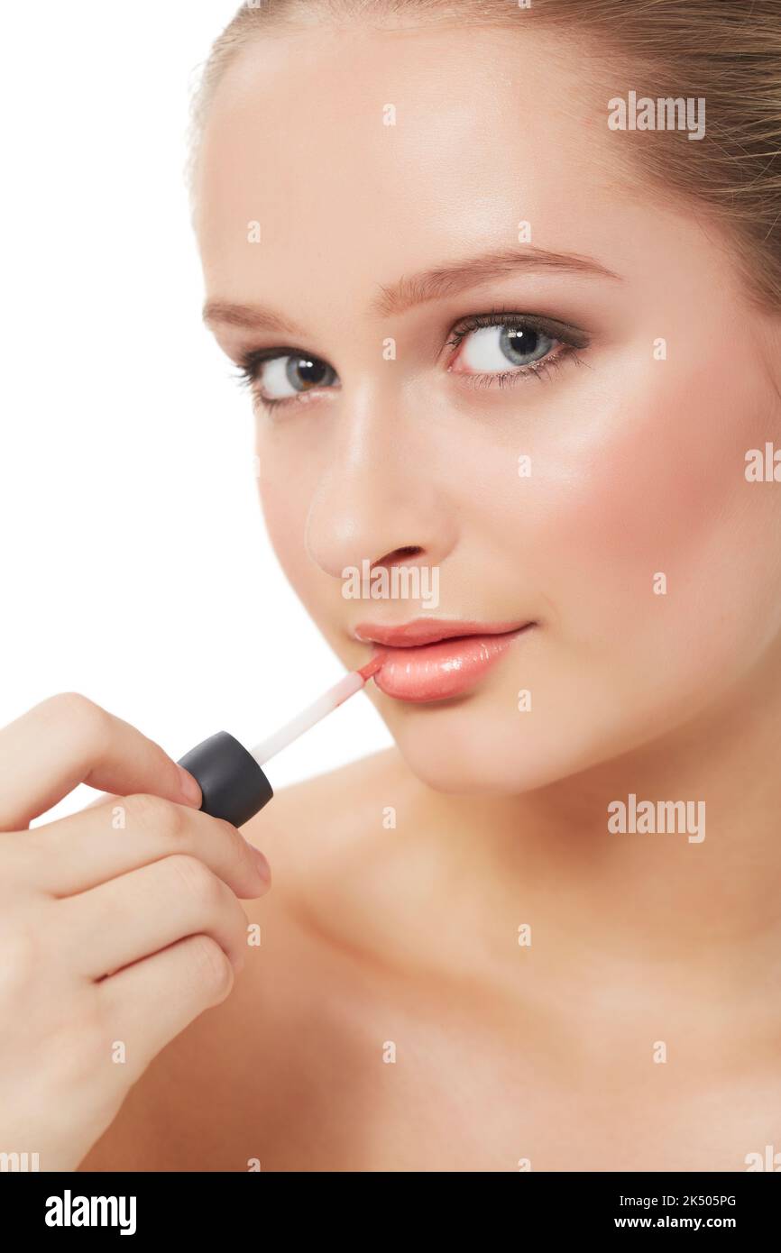 Fulling Out Her Lips A Stunning Young Woman Applying Lipgloss To Her Luscious Lips While