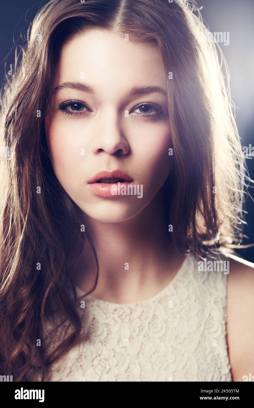 Trapped in her gaze. A gorgeous young woman backlit with bright lights ...