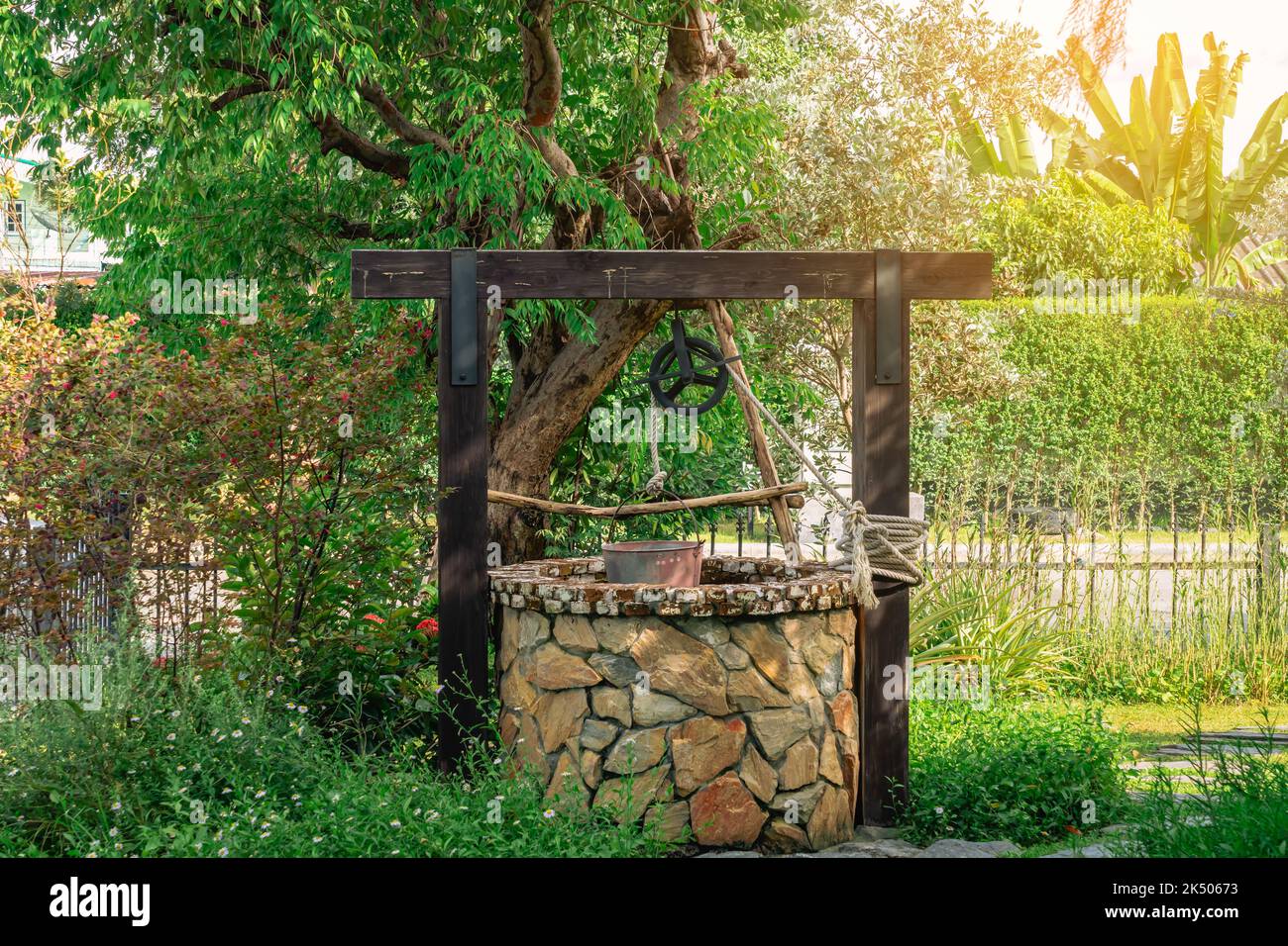 Beautiful artesian well made by stones and wheel pulley with metal ...