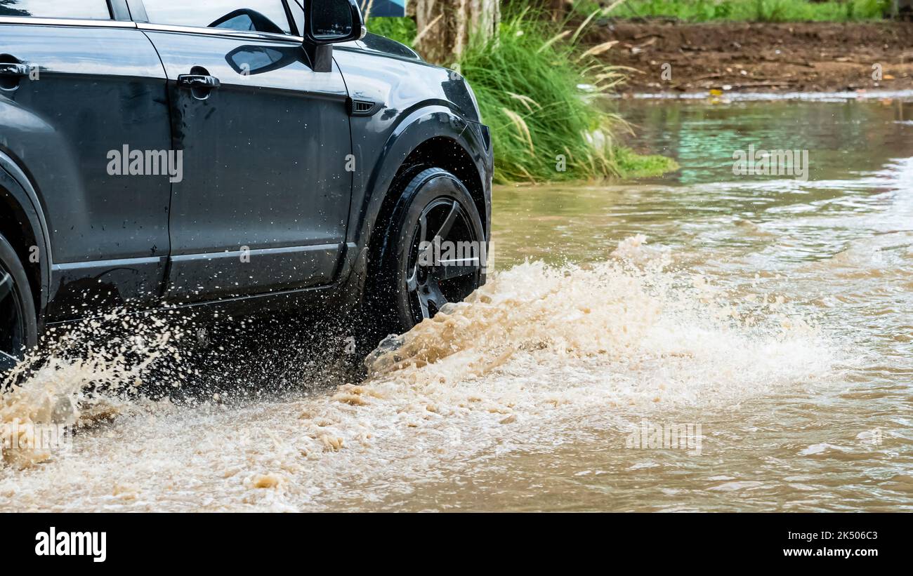 Car passing through a flooded road. Driving car on flooded road during ...