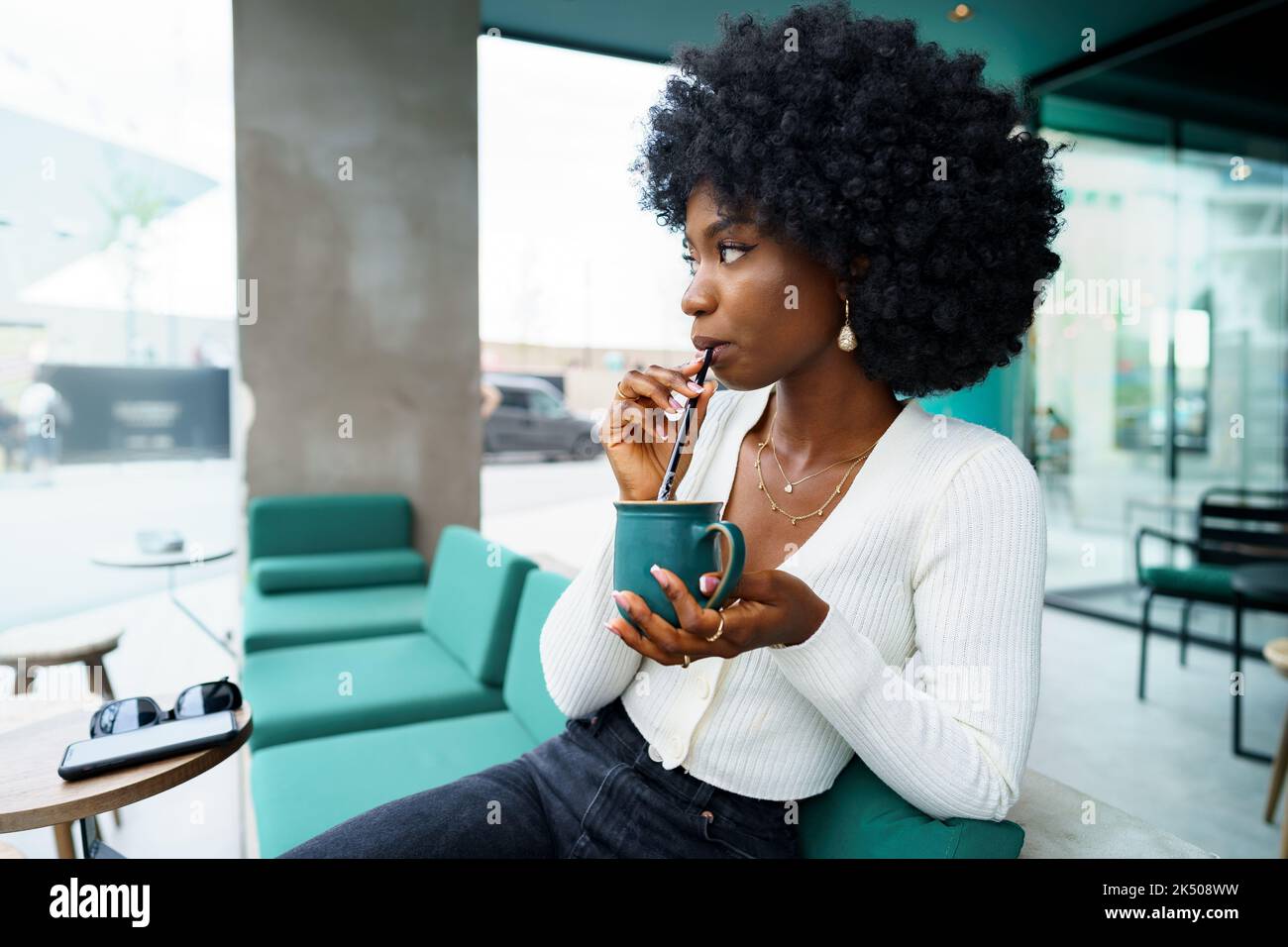 Young woman taking break and drinking coffee in cafe Stock Photo - Alamy