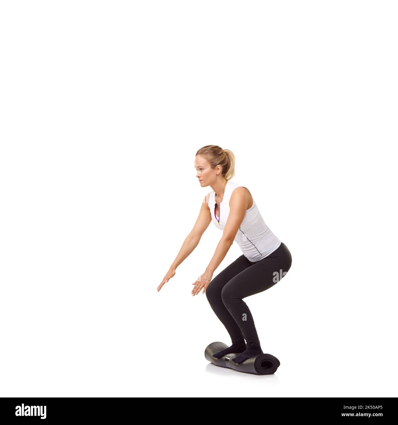 Holding her crouching stance. A pretty young woman balancing on her ...