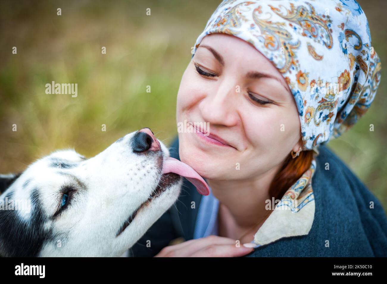 A young girl while walking in the Park with a dog, hugging the dog ...