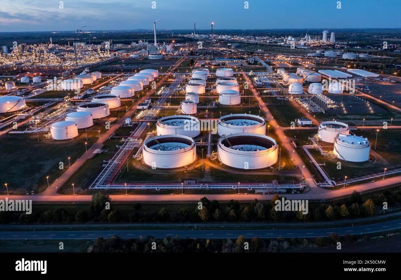 04 October 2022, Saxony-Anhalt, Leuna: Behind the illuminated tank farm ...