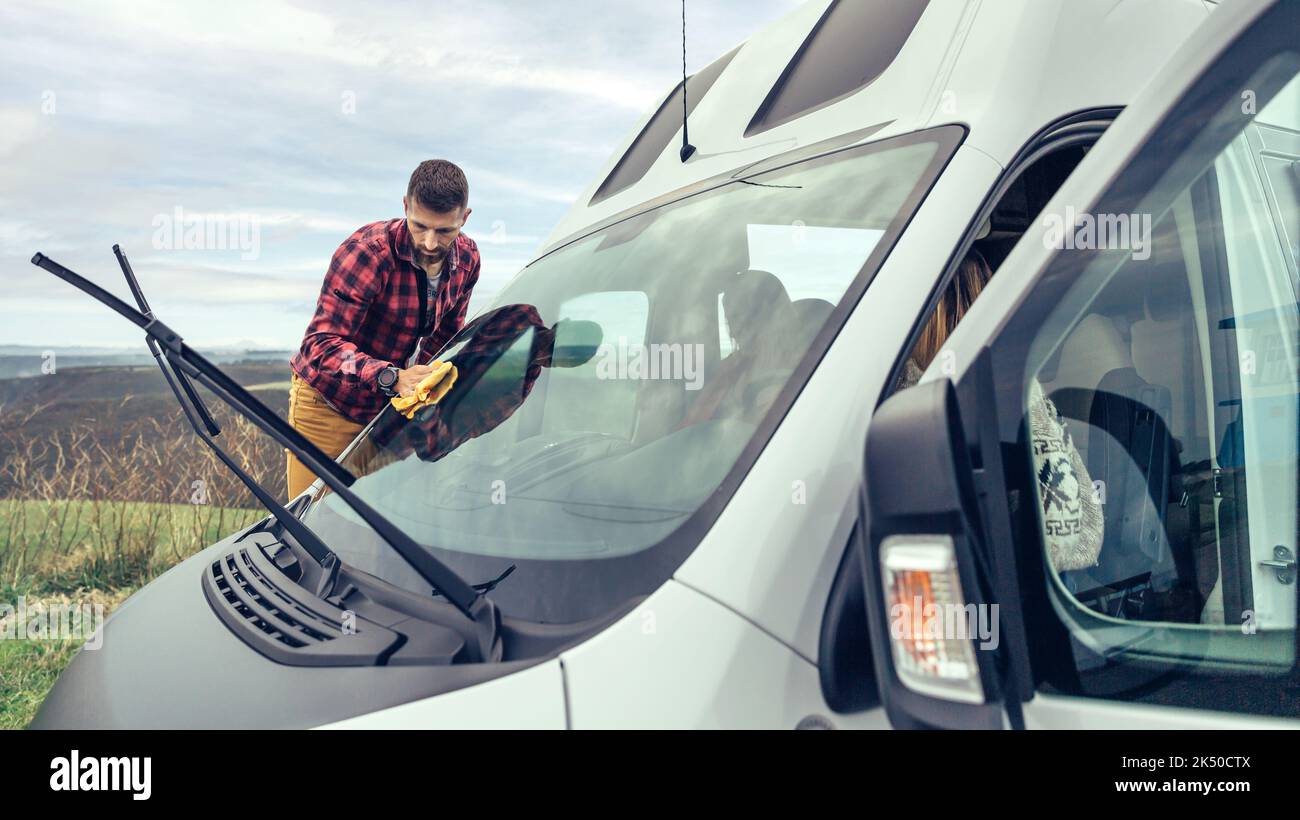 Man cleaning camper van windshield outdoor Stock Photo - Alamy
