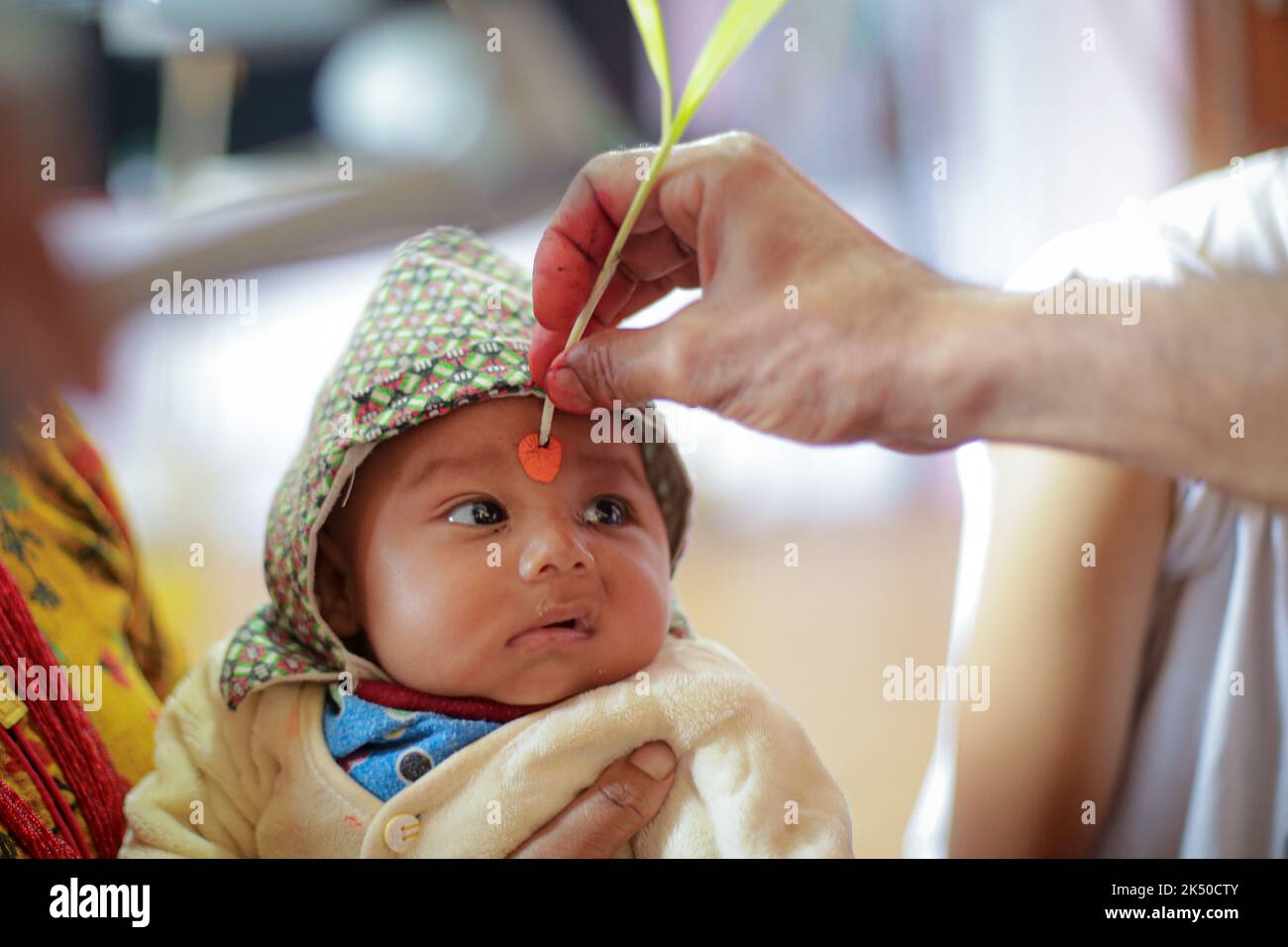 Nepal. 5th Oct, 2022. A small child receives tika and blessings from ...