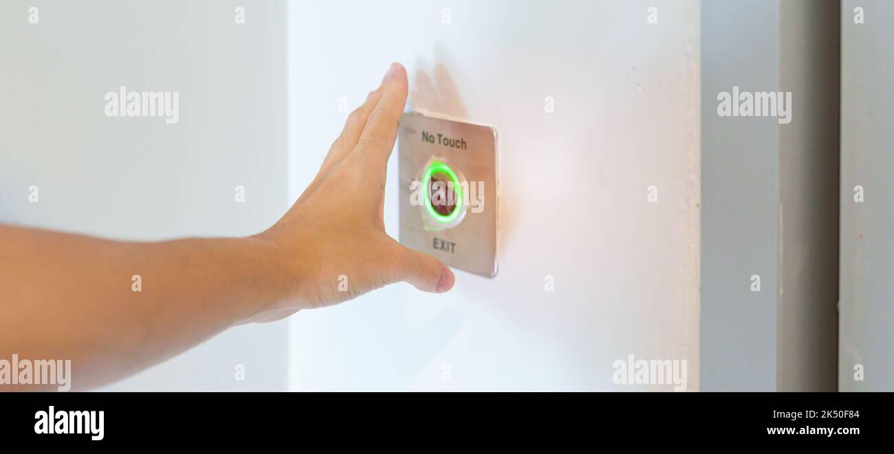 Hand open the door by No touch sensor switch on the wall at office or ...