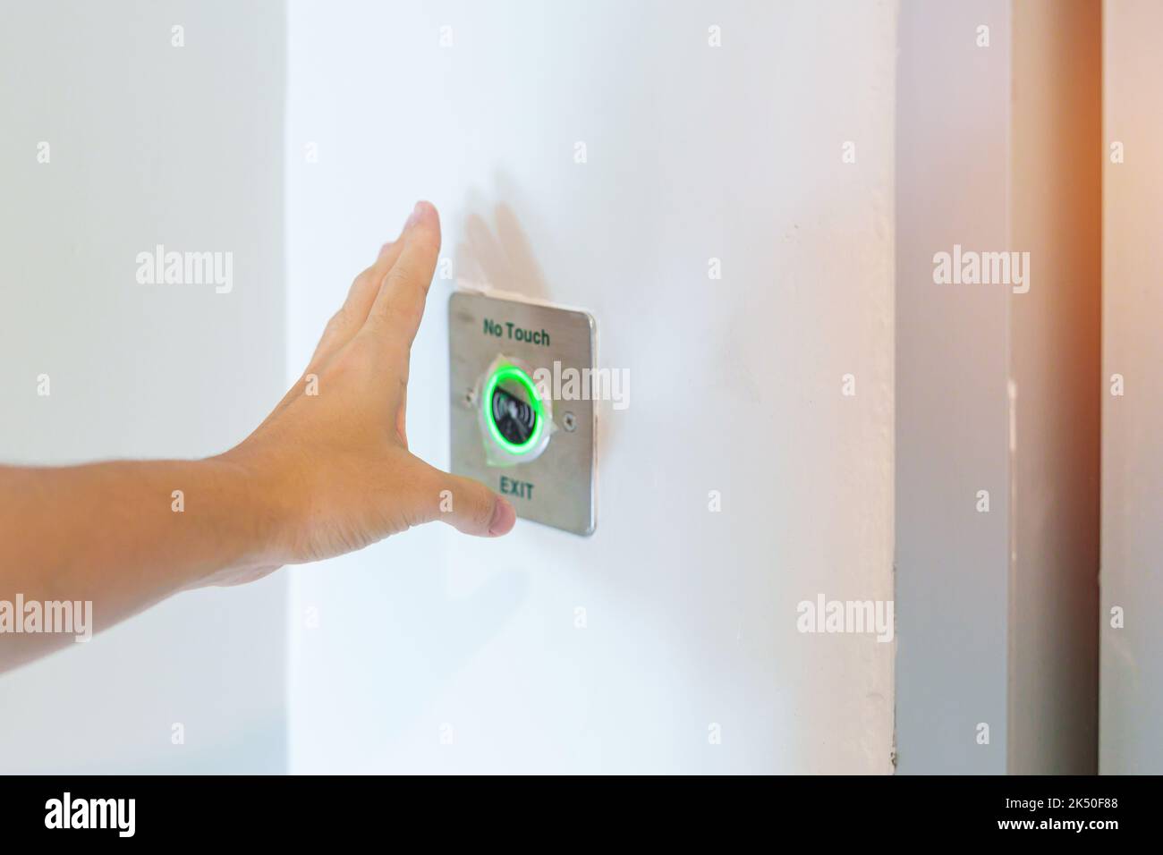 Hand open the door by No touch sensor switch on the wall at office or ...