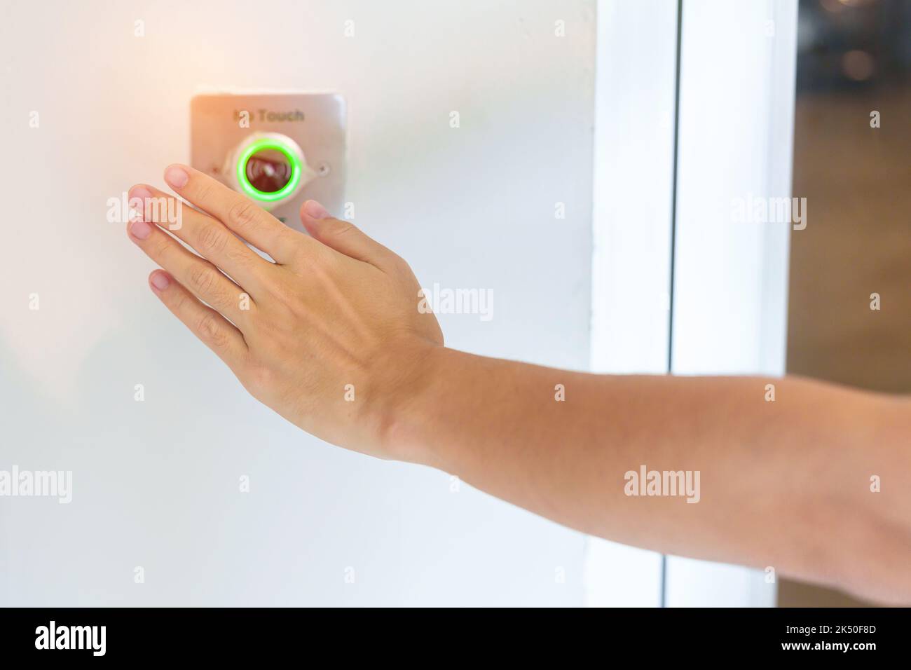 Hand open the door by No touch sensor switch on the wall at office or ...