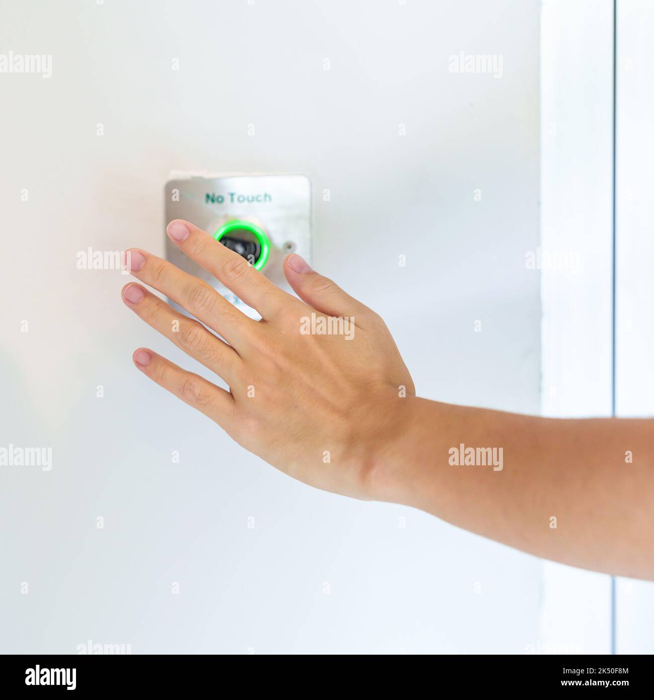 Hand open the door by No touch sensor switch on the wall at office or ...