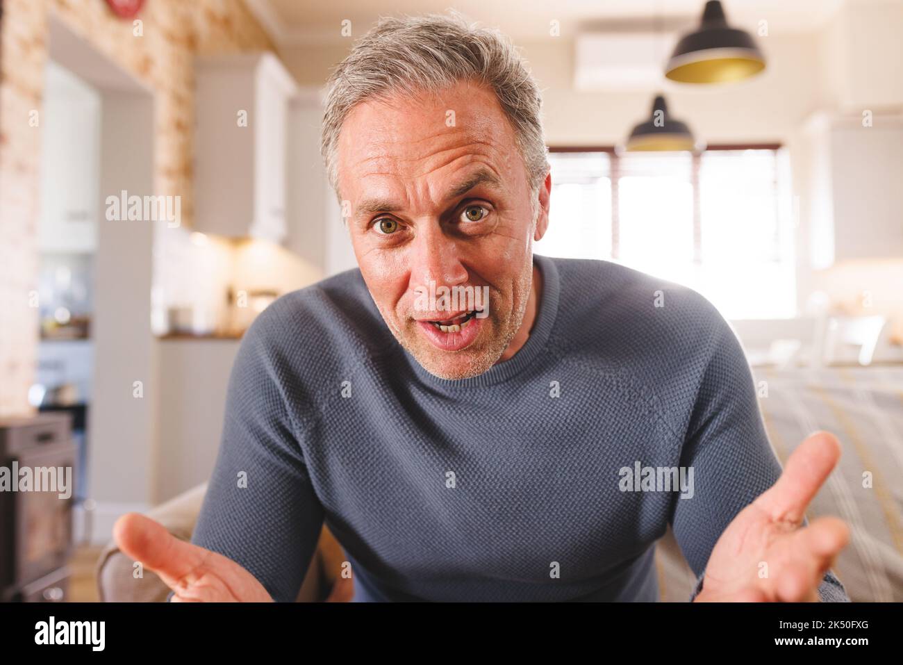 Happy caucasian man sitting on sofa in living room and having video ...