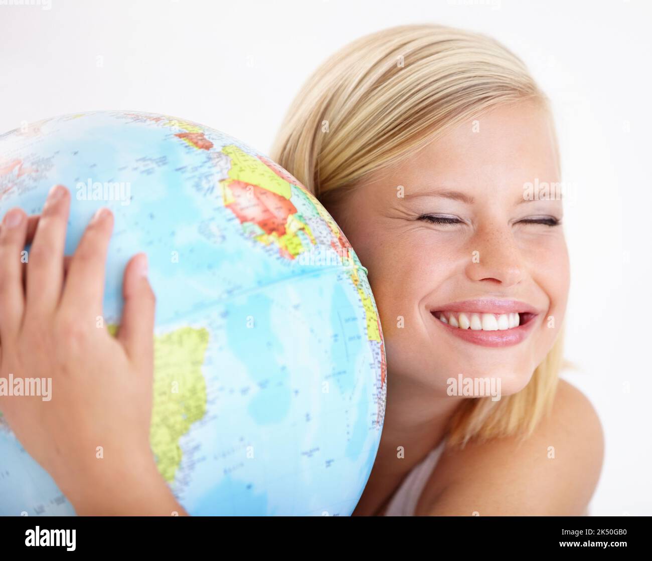She loves earth. A pretty young woman hugging a globe of the earth ...