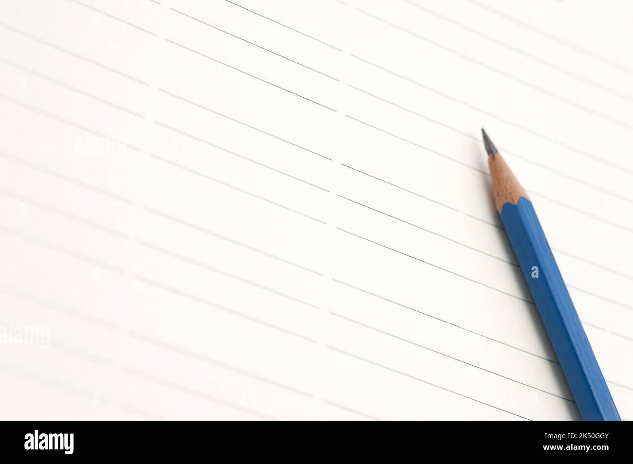 Sharp blue pencil on lined paper with space to place your message or ...