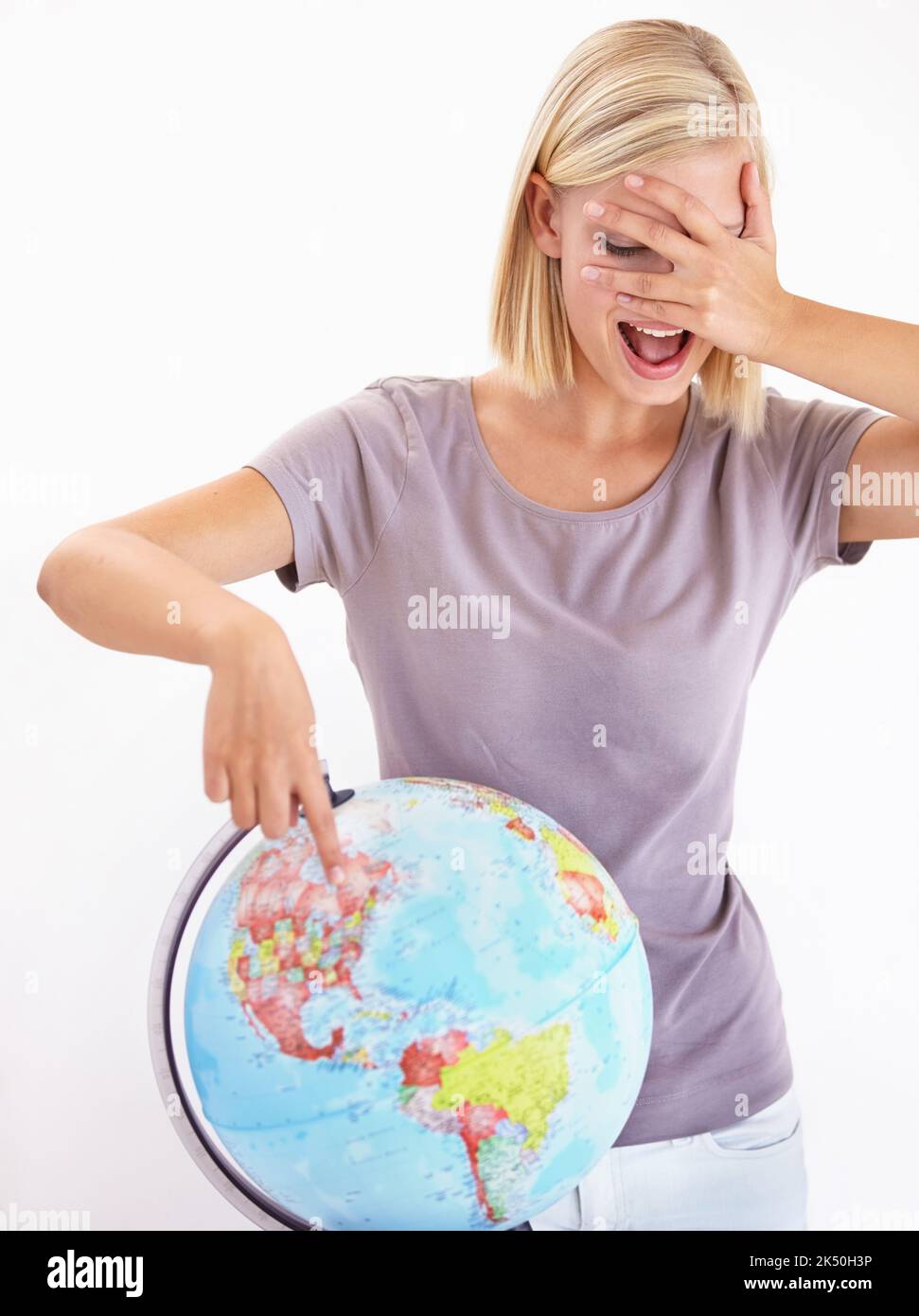 Where am I headed to next. A pretty young woman covering her eyes and ...