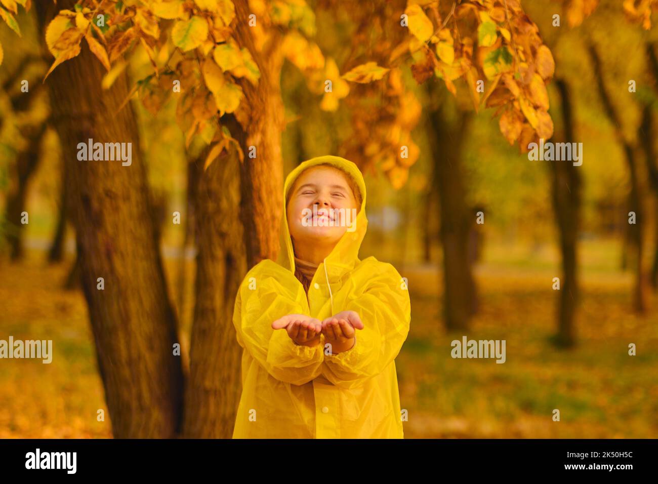 happy kid catching rain drops in Autumn park Stock Photo - Alamy
