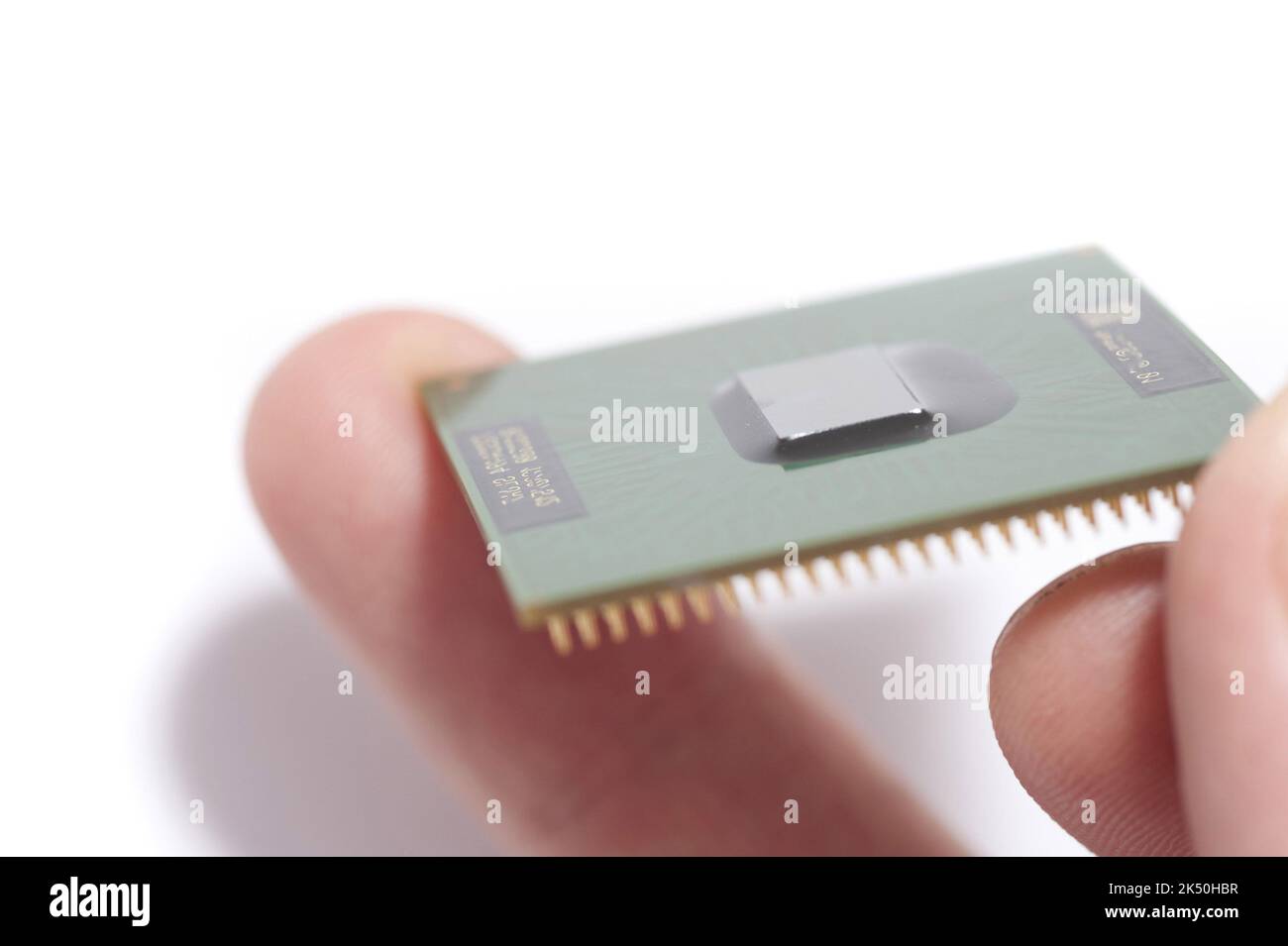 Close-up image of man holding CPU chip in fingers against white ...