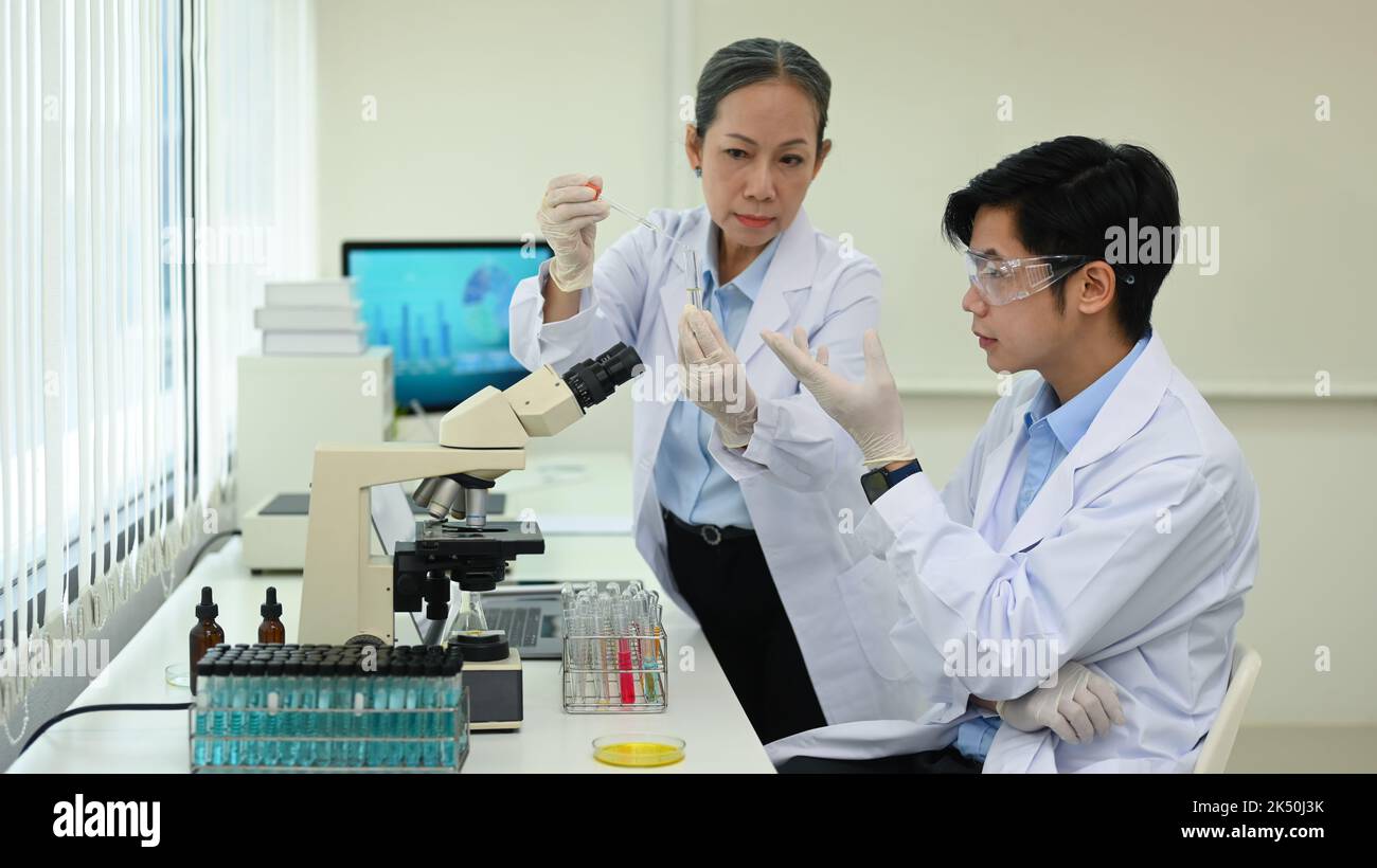 Professional scientists team conducting experiment in modern laboratory ...