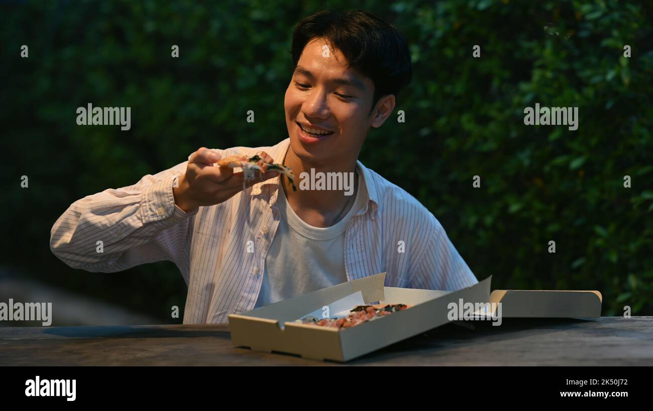 Happy man eating pizza night hi-res stock photography and images - Alamy