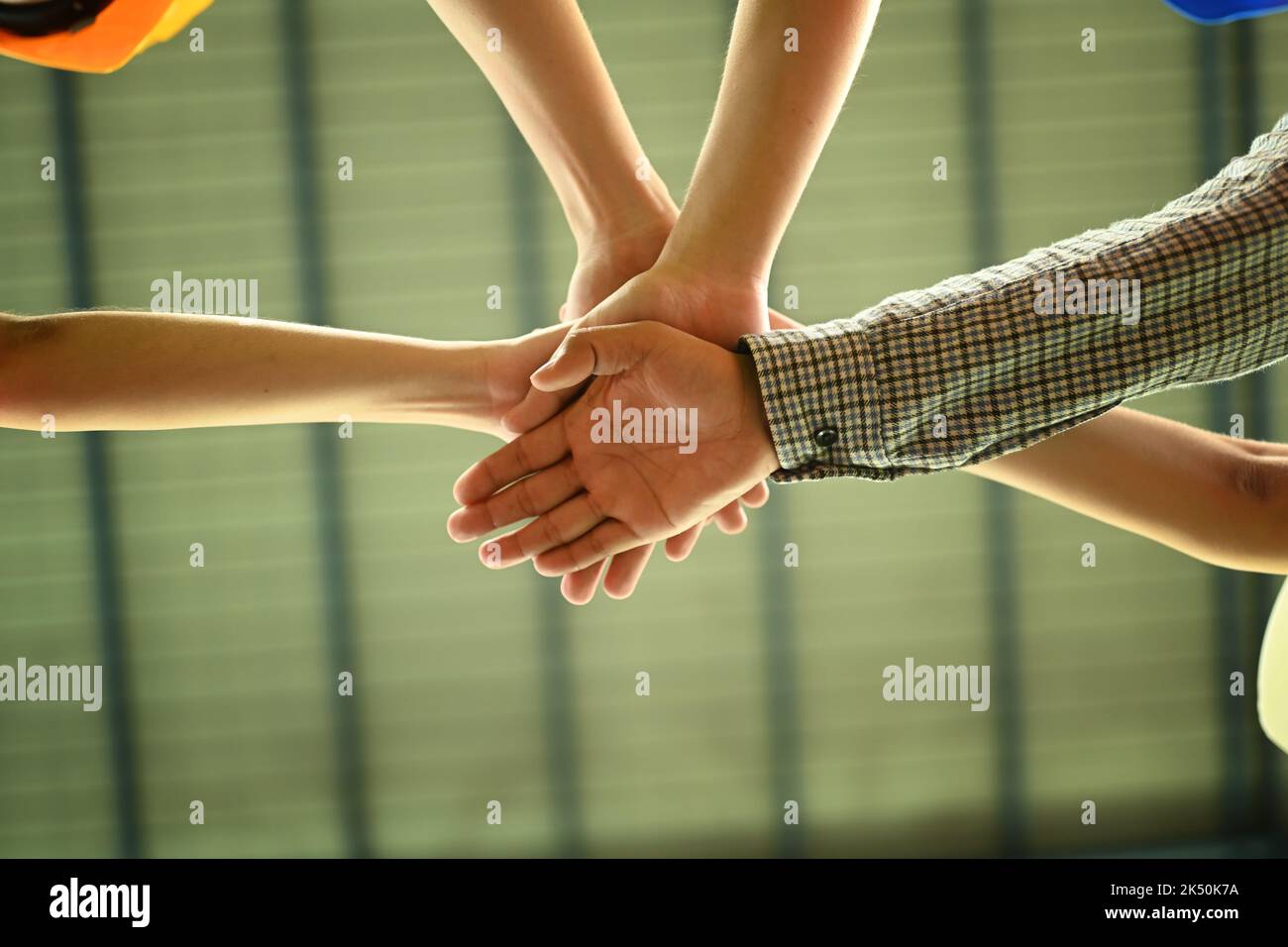 Low angle closeup of warehouse worker stacking of hands showing the ...