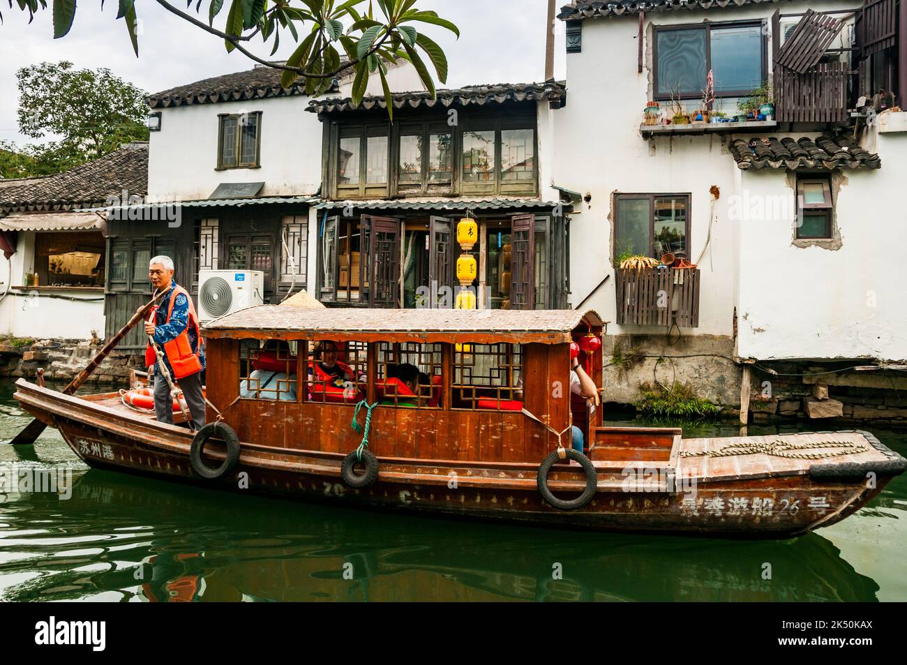 A boatman rowing a tourist boat on Pingjiang River alongside Pingjiang ...
