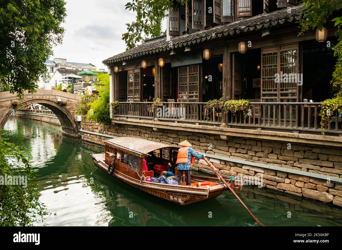 A tourist boat passing a teahouse on Pingjiang River alongside ...