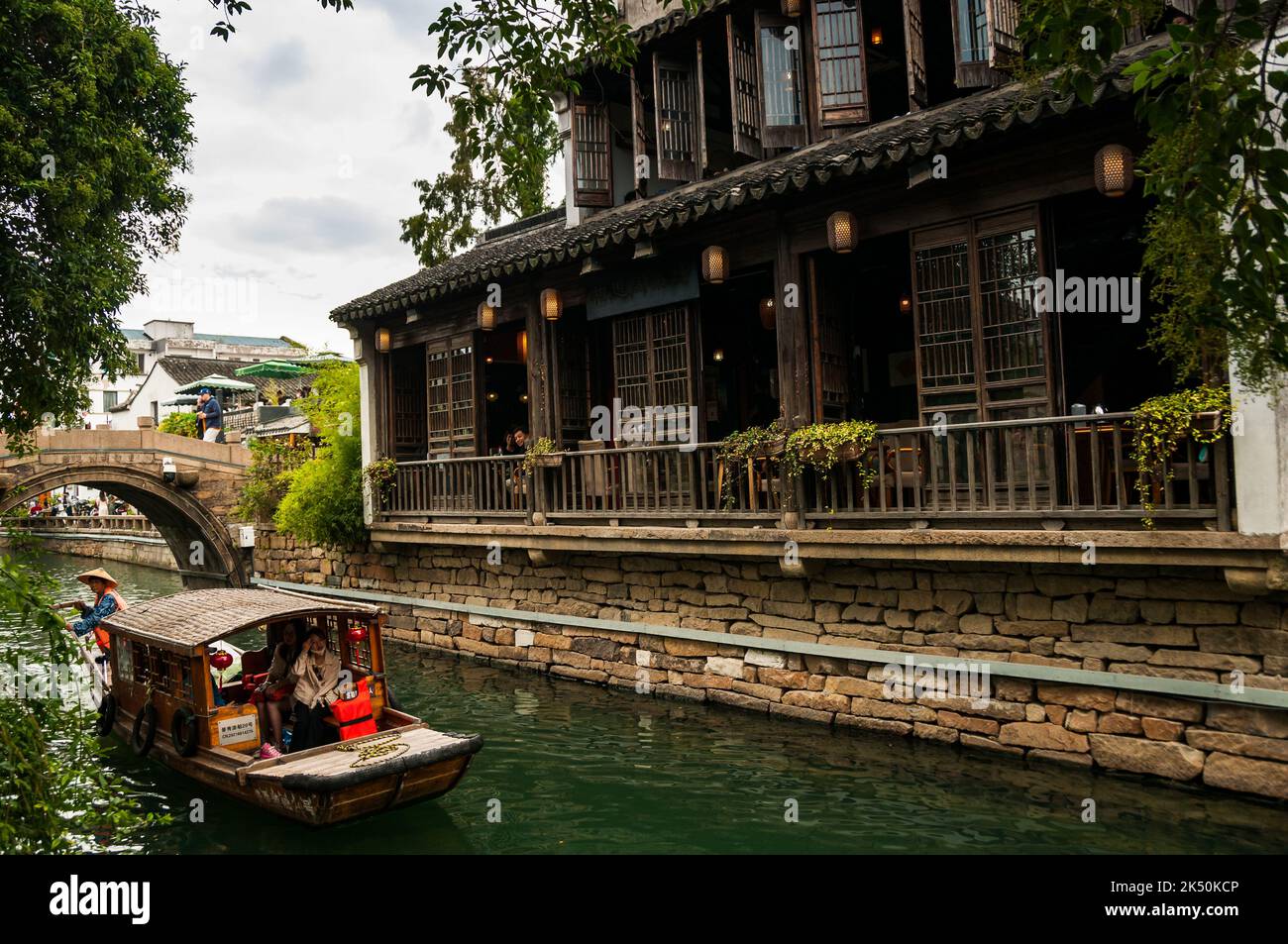 A tourist boat passing a teahouse on Pingjiang River alongside Pingjiang Lu a street full of old ...