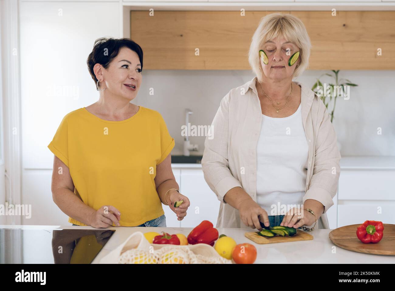 Happy senior women in kitchen cooking together. Mature women in kitchen ...