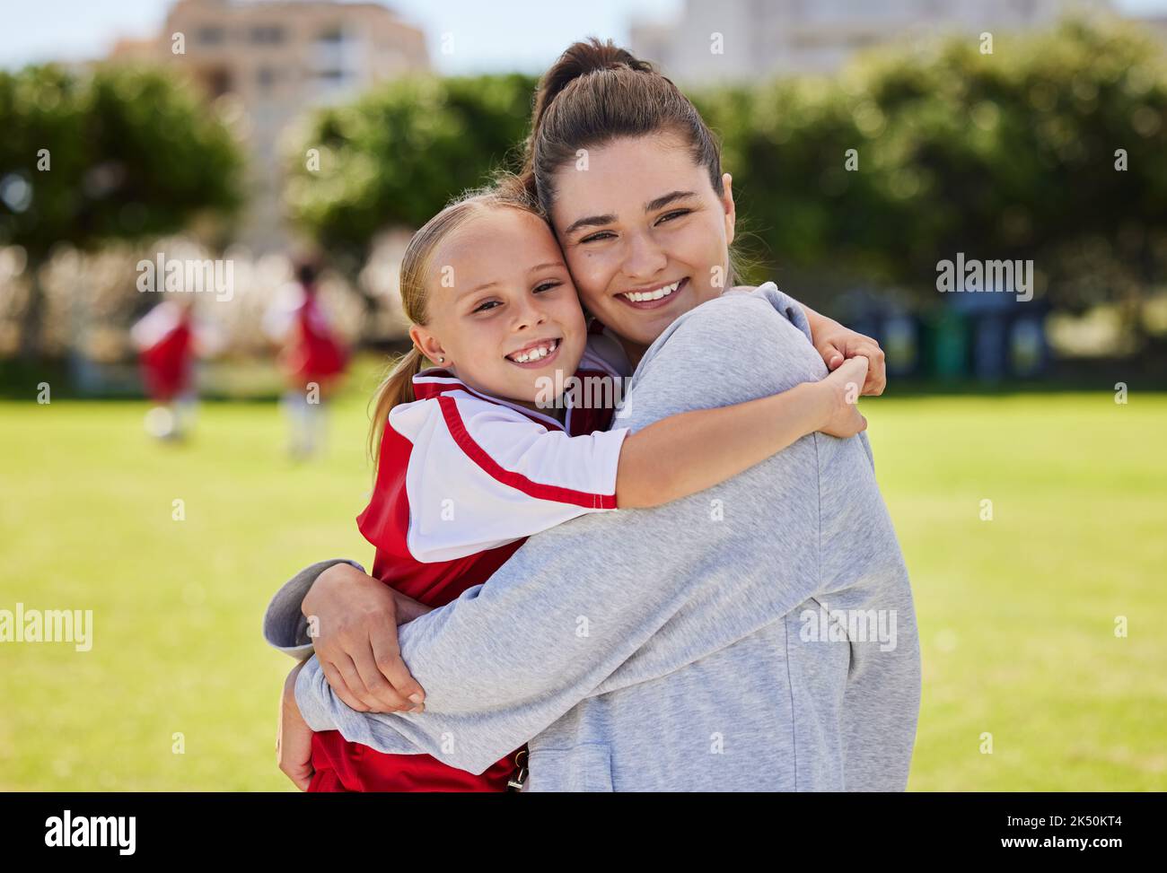 Portrait of mother and girl hug at soccer training, bonding and ...