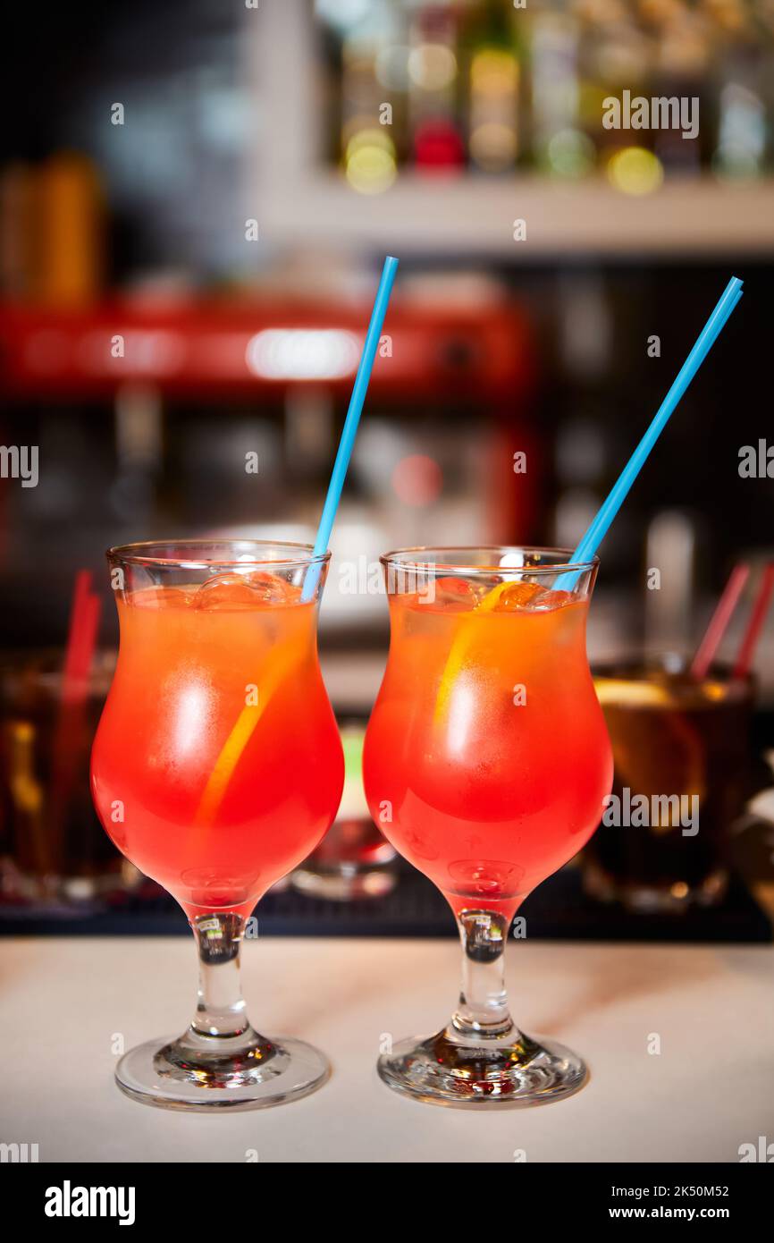 Red Alcoholic cocktails decorated with slices of orange on the bar ...