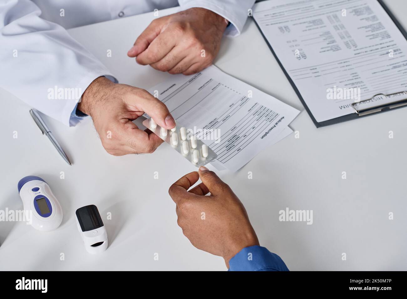Close-up of doctor giving medicine to patient while they sitting at ...