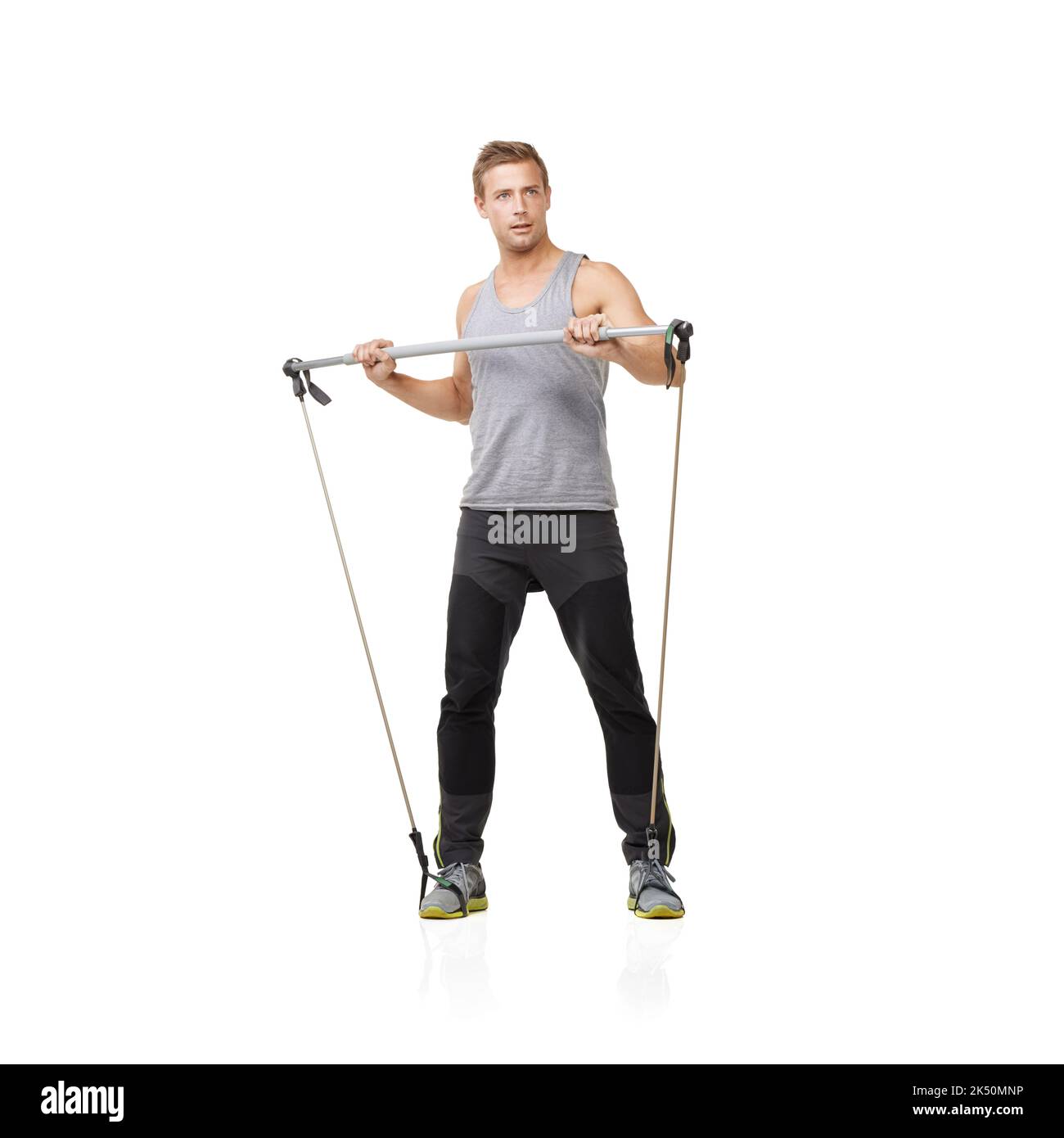 Fitness is his goal. A young man using a resistance band to tone his ...