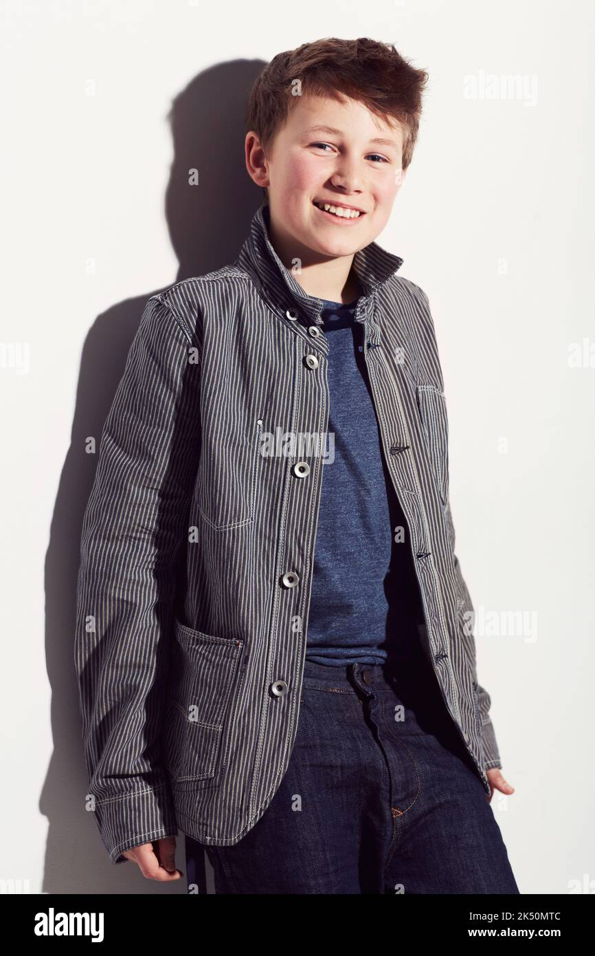 Stylish despite his young age. Young adolescent boy standing against a ...