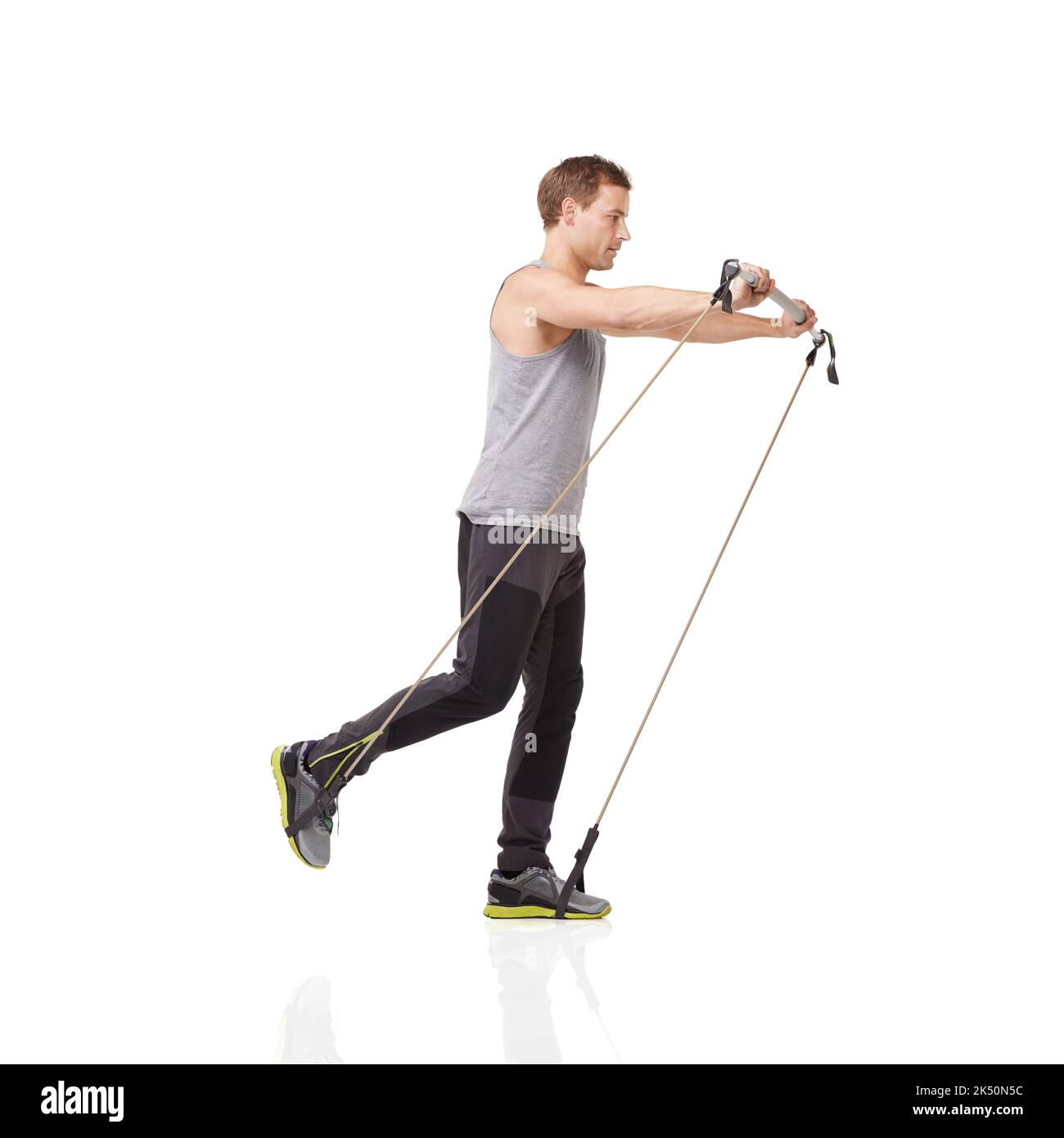 Fitness in motion. A young man using a resistance band to tone his body ...