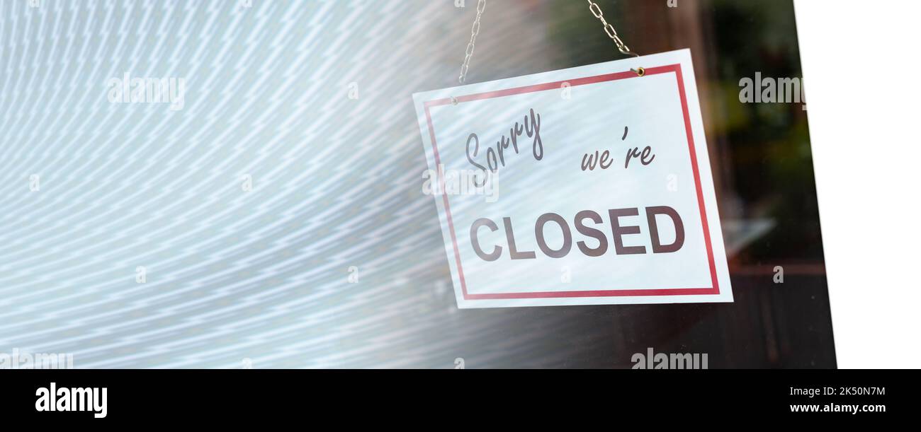 Sorry we're closed sign hanging behind a store window; panoramic banner ...