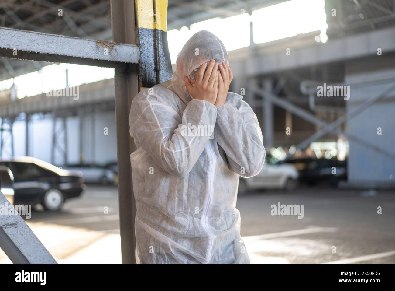 Despair healthcare worker in white covid protective overalls.Tired Male ...